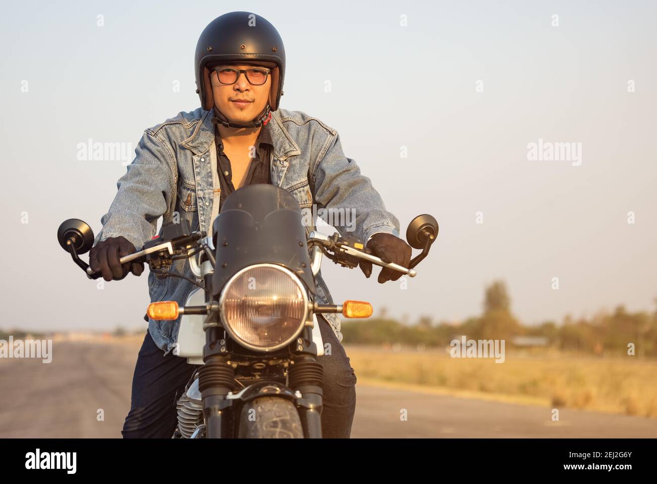 Young man riding big bike motocycle on asphalt high way against ...