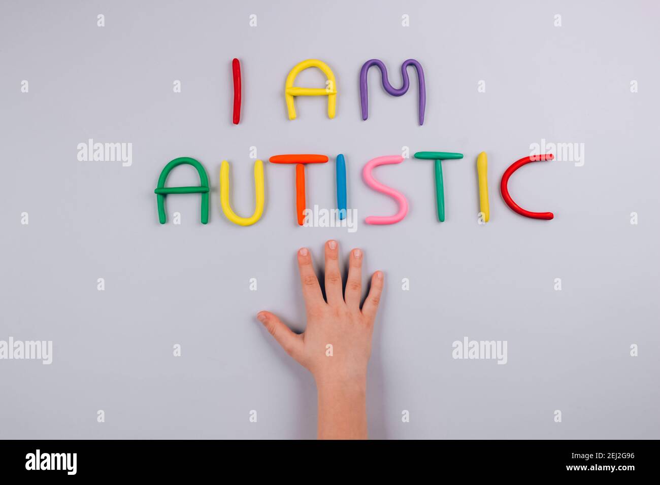 Multicolored letters, I am Autistic - on light gray background with ...