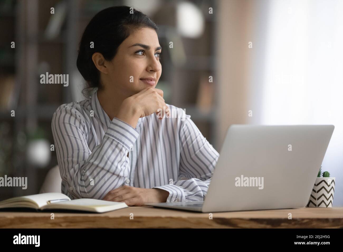 Dreamy Indian woman work on laptop thinking Stock Photo - Alamy