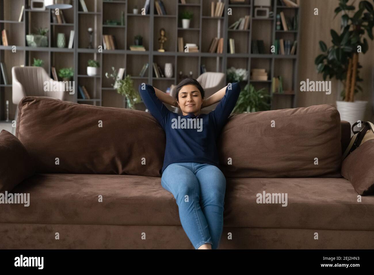 Happy Indian female renter relax on sofa at home Stock Photo - Alamy