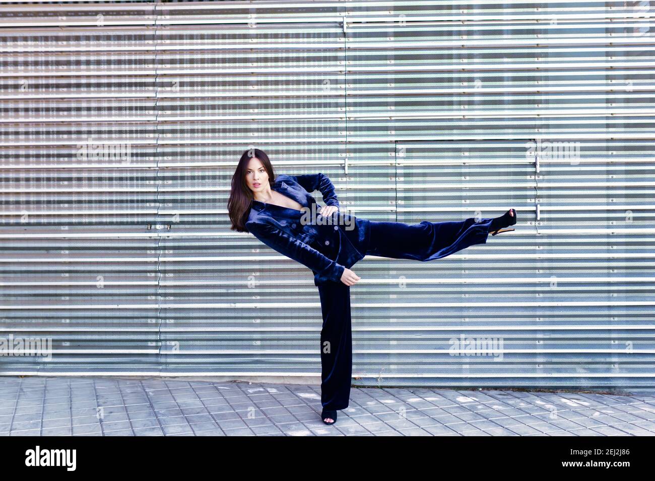 Woman wearing blue suit posing near a modern metal building Stock Photo ...