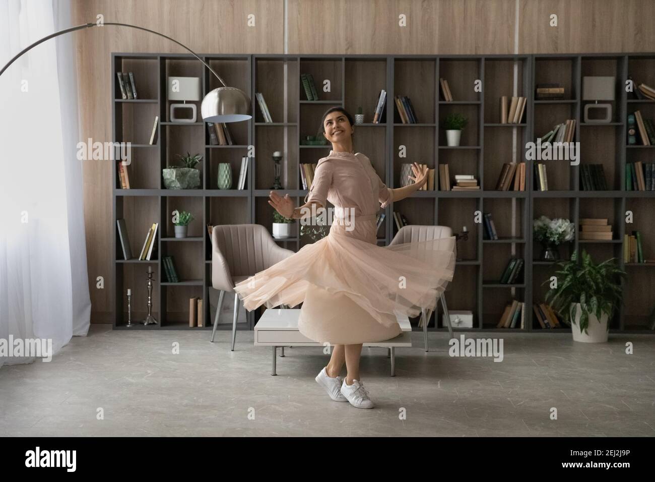Happy young Indian woman dance in cozy living room Stock Photo - Alamy