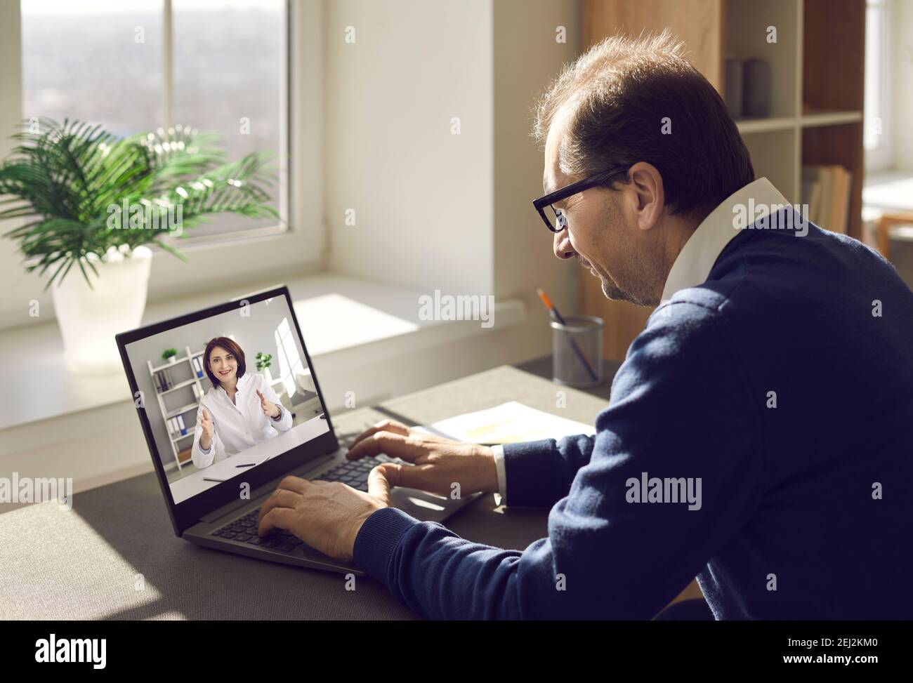 Man using his laptop, enjoying virtual visit to clinic and consulting ...