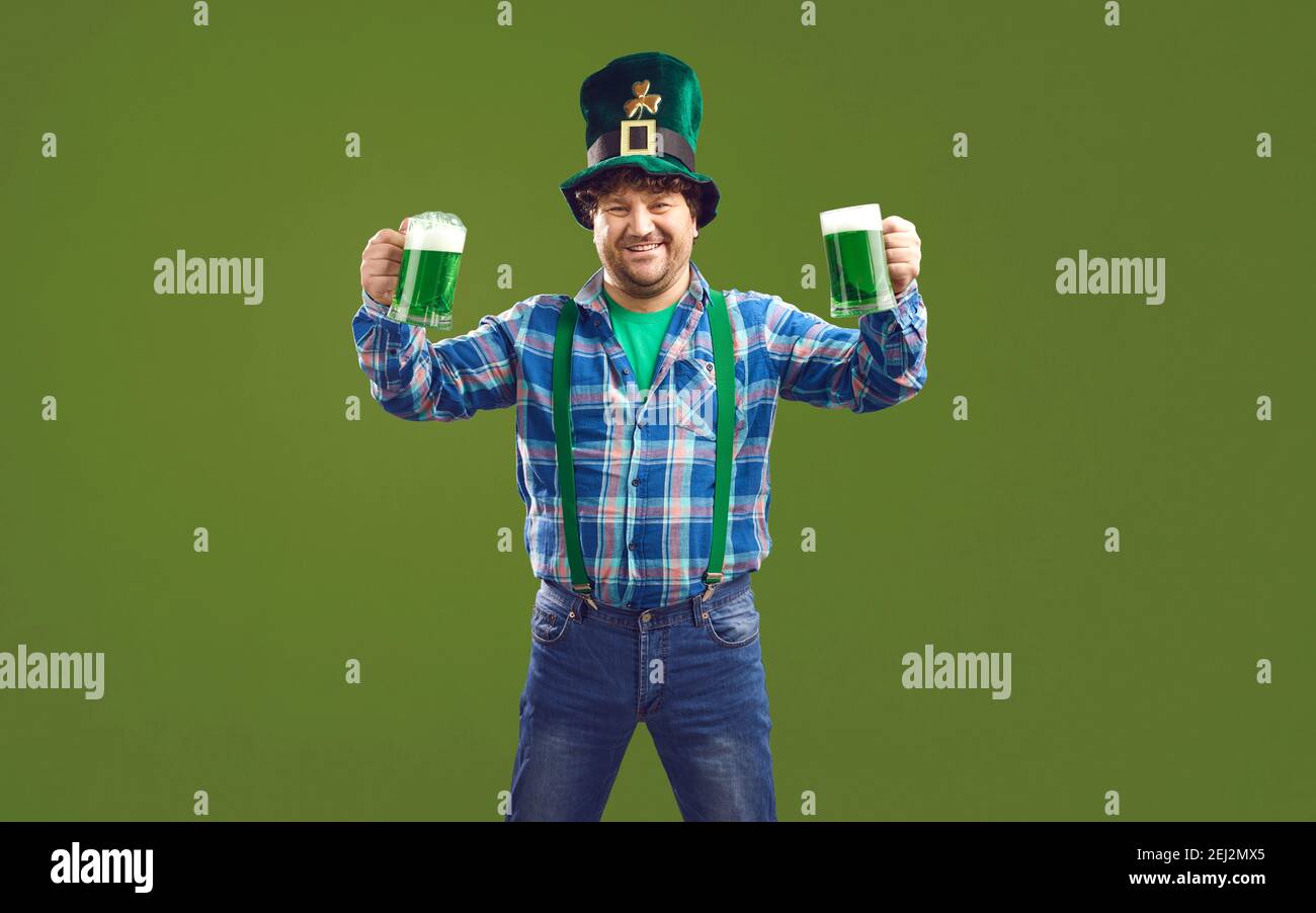 Positive man holding mugs of green beer for Patricks day Stock Photo ...