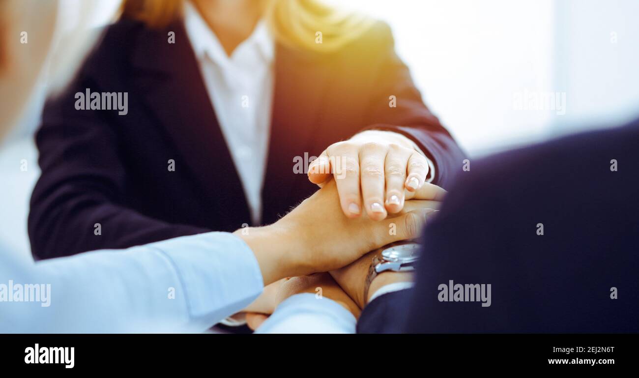 Business team showing unity with their hands together in sunny office ...