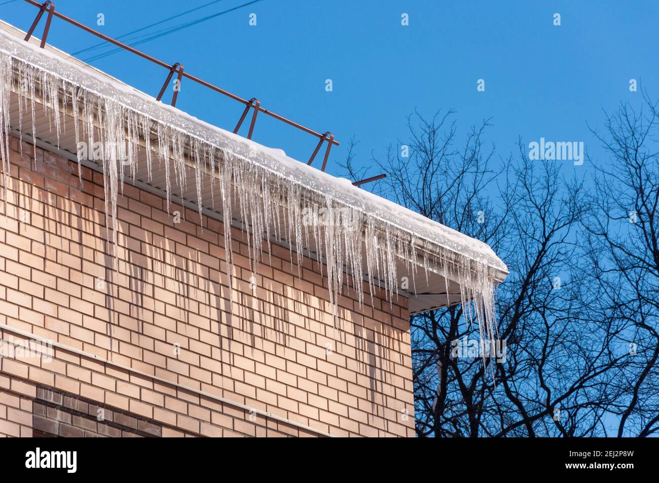 Roof Of The House With Snow And Icicles Overhanging Stock Photo - Alamy