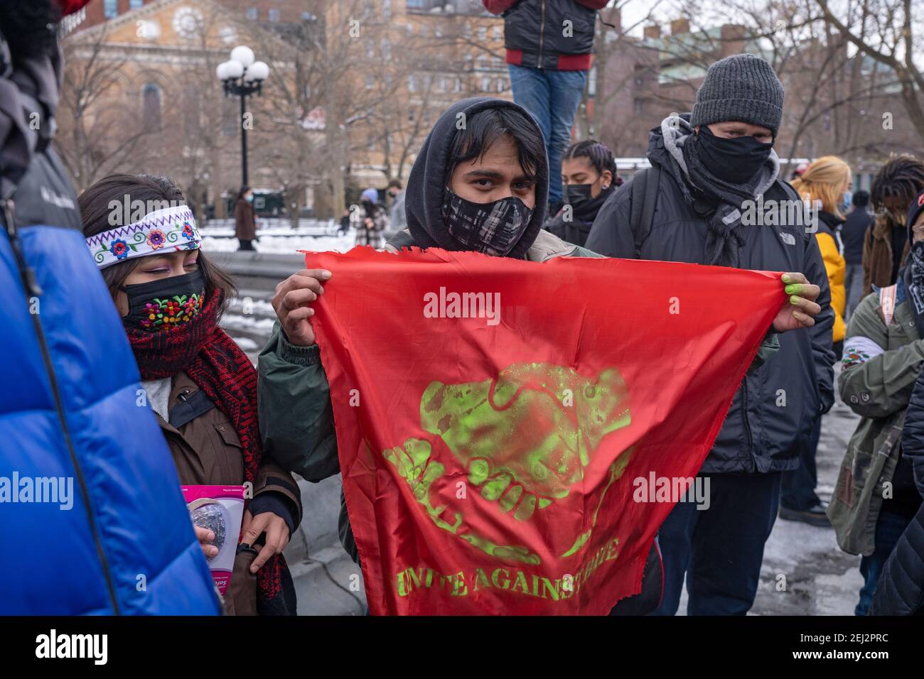 A protestor holding a banner that reads "unite against hate" during the ...