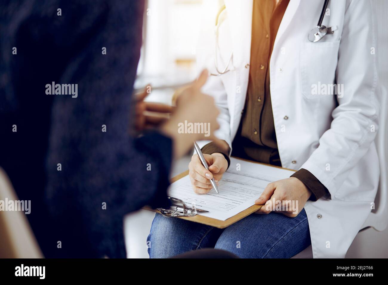 Doctor and patient discussing current health examination while sitting ...