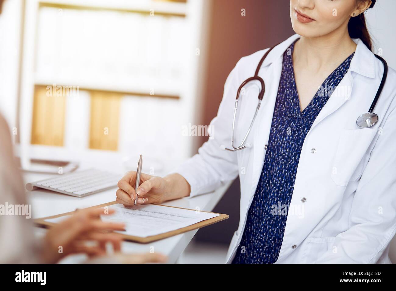 Doctor and patient discussing current health examination while sitting ...