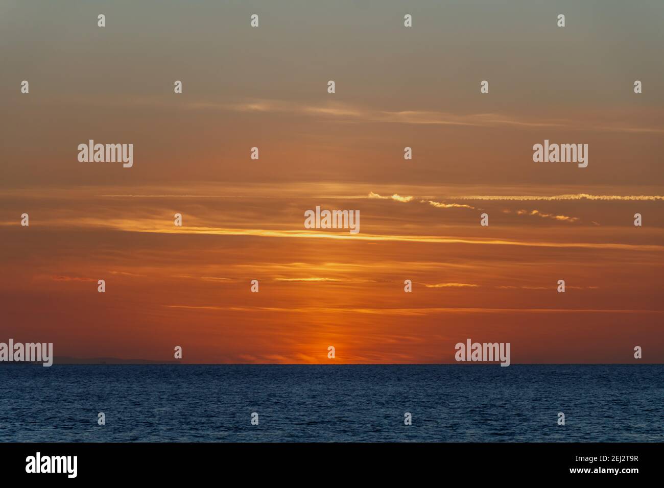 The sun setting over the horizon Stock Photo - Alamy
