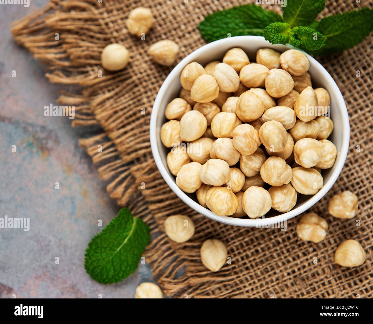 Peeled hazelnuts in a bowl on grey concrete background Stock Photo - Alamy