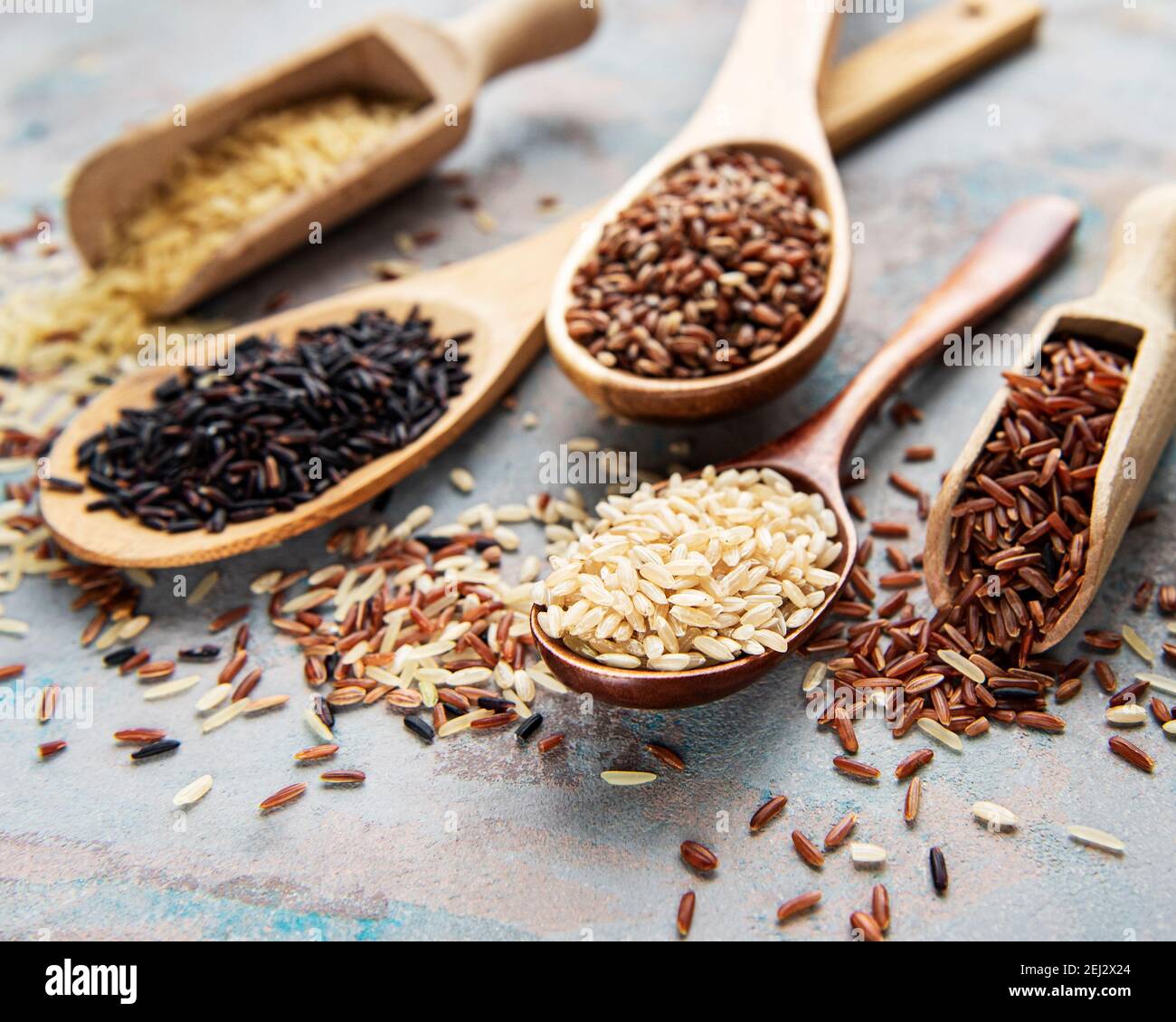 Set of various rice on concrete background: black, basmati, brown and ...