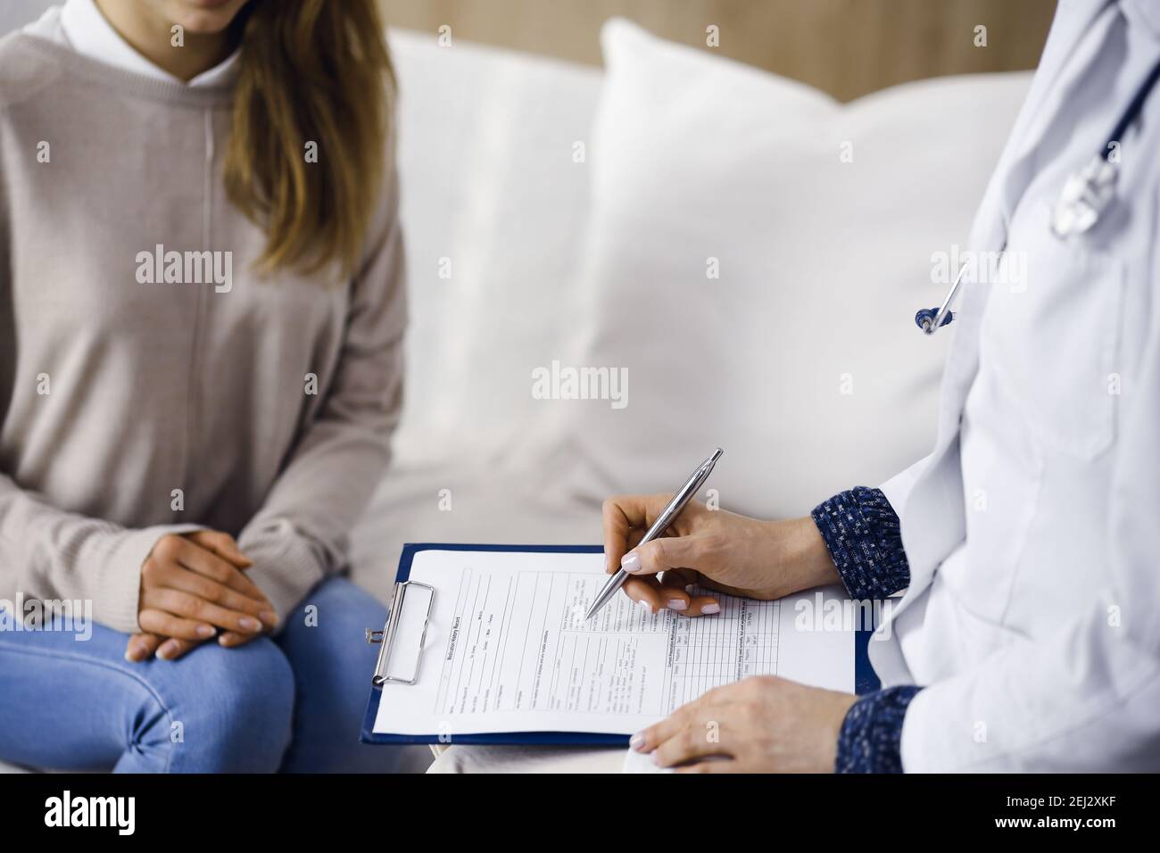 Unknown woman-doctor and patient discussing current health examination ...
