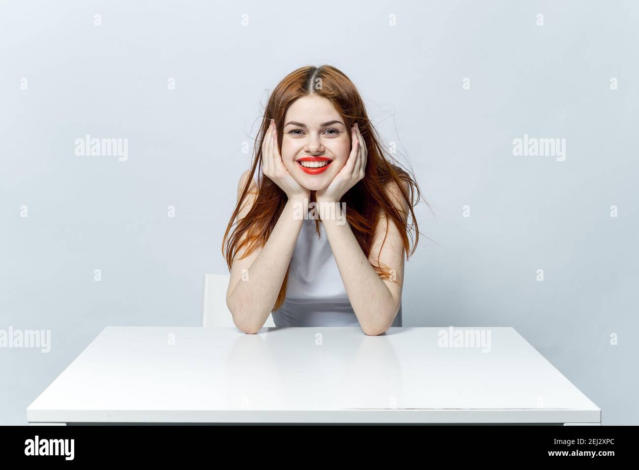 emotional pretty woman sitting at the table gesturing with hands red ...