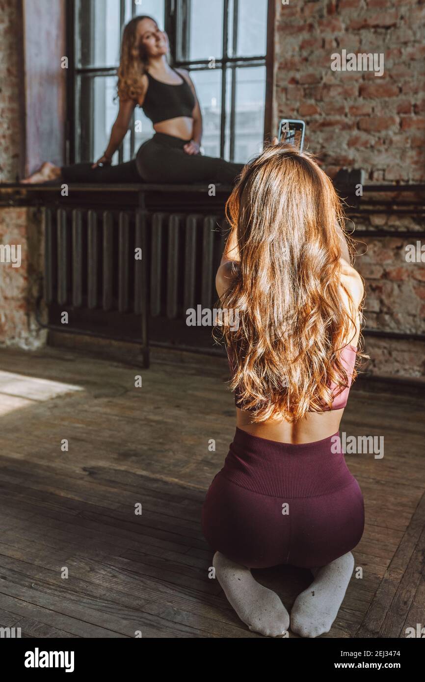 Two female friends take photo after hard workout loft style studio ...