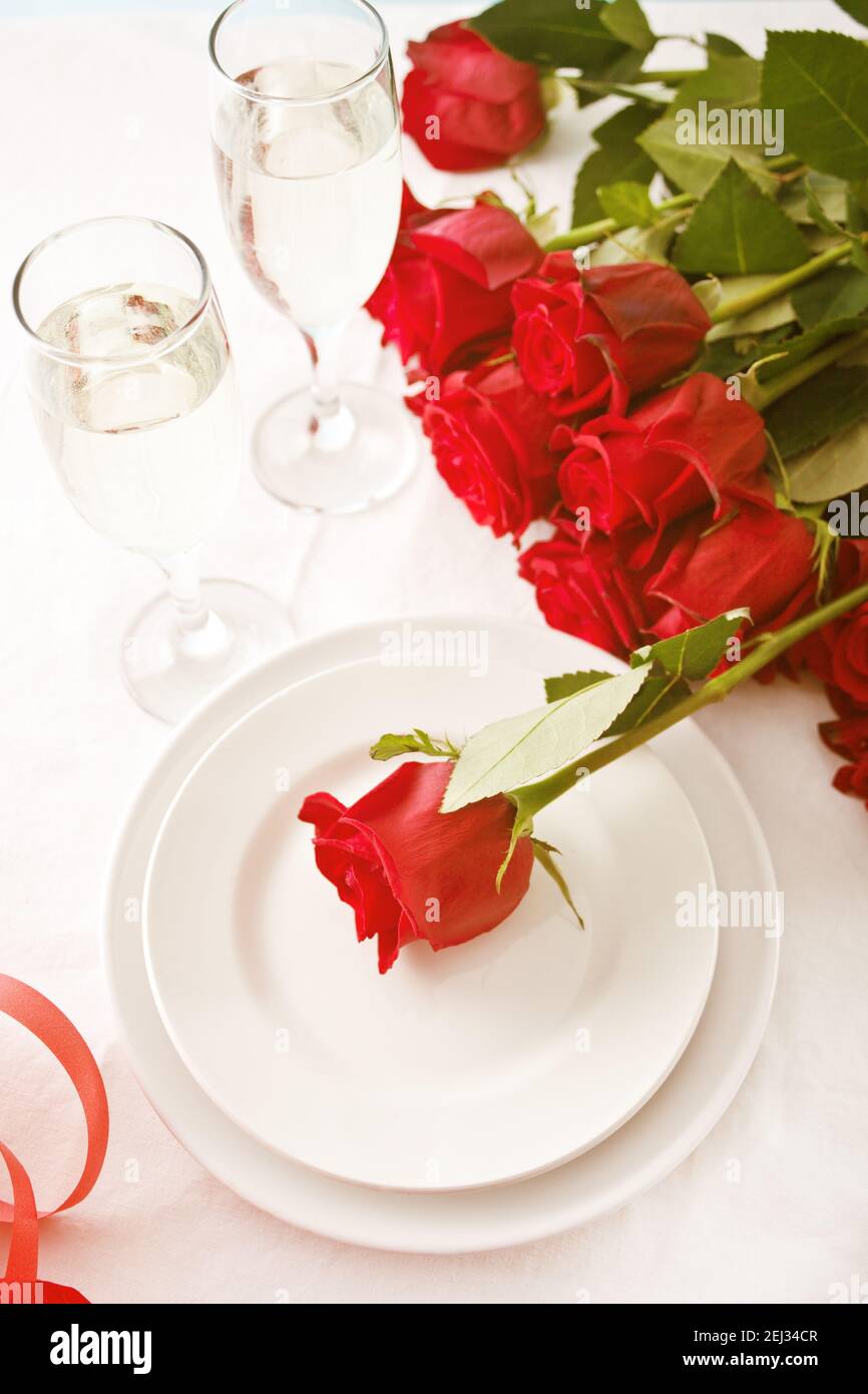 Romantic restaurant table setting for two with roses, plates and ...