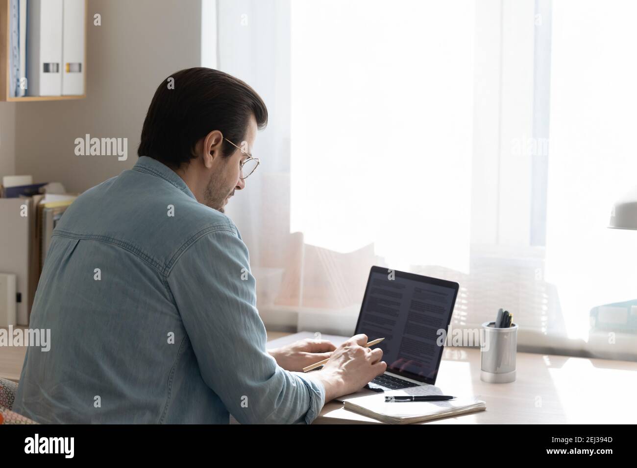 Back view of man work online on computer Stock Photo - Alamy