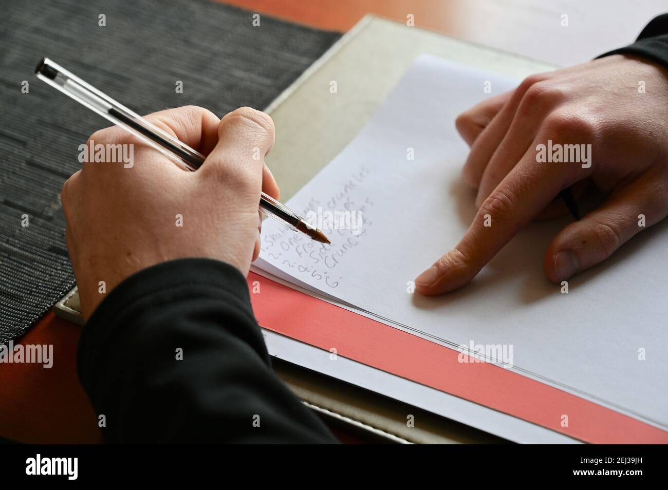 Close up of a left handed young man writing a list Stock Photo - Alamy