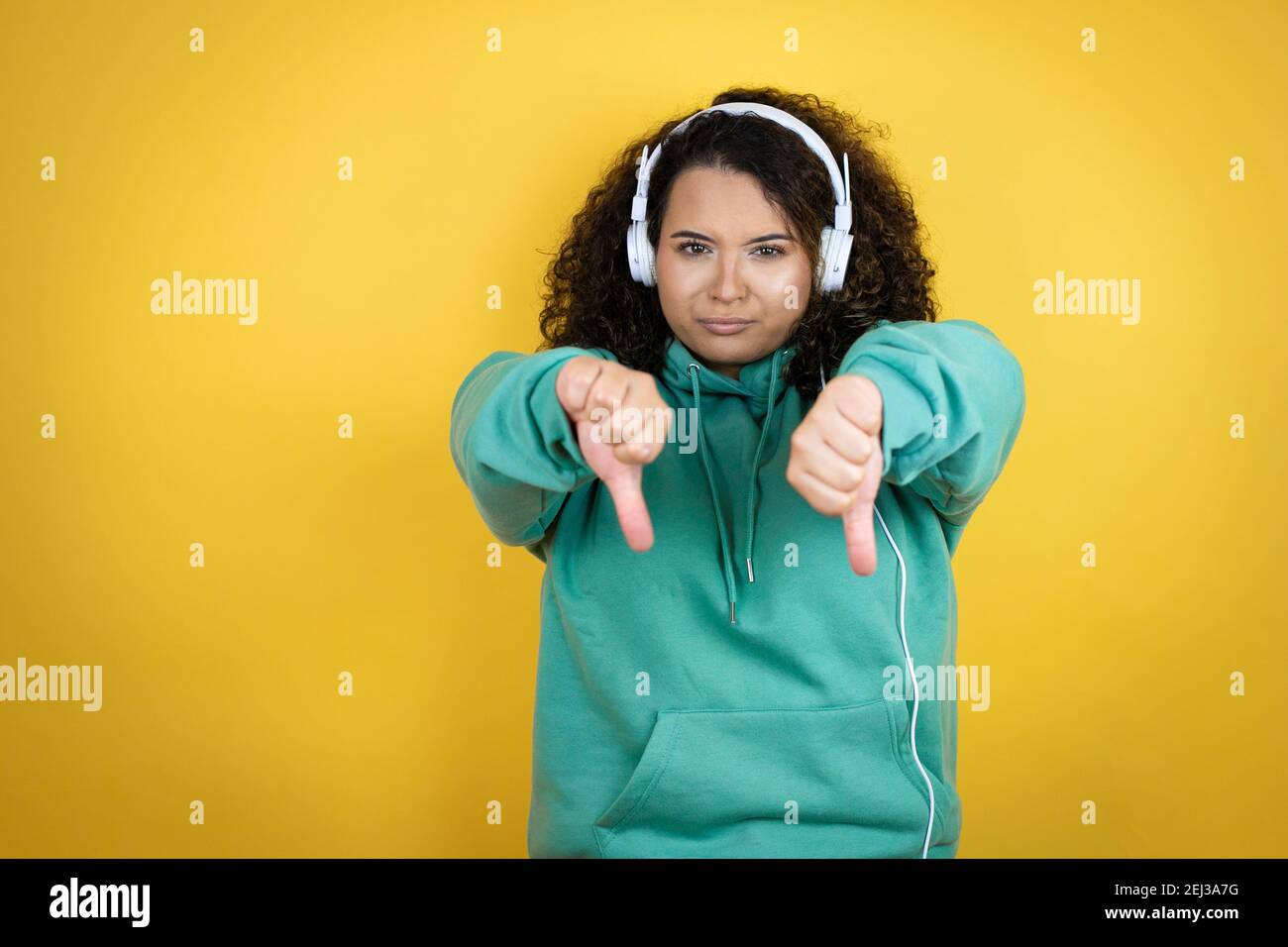 Young african american girl wearing gym clothes and using headphones ...