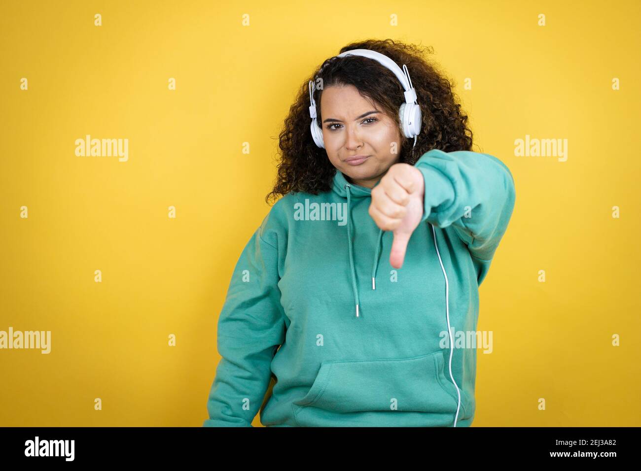 Young african american girl wearing gym clothes and using headphones ...
