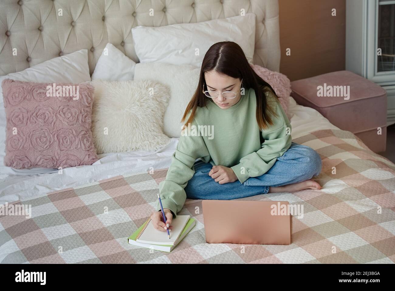 Cute teenager girl doing homework.Young girl wearing glasses writing ...
