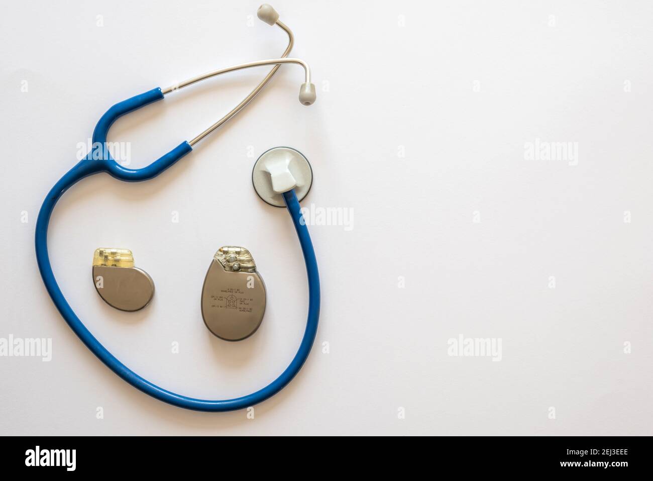 TWO PACEMAKER BATTERIES SURROUNDED BY A BLUE STETHOSCOPE WHITE ...