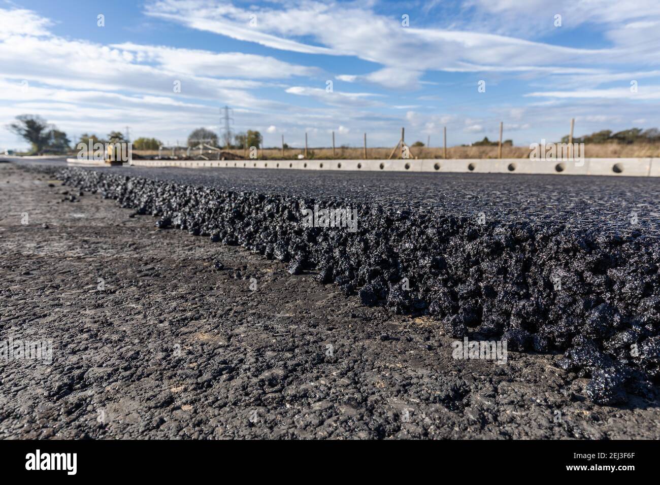 A layer of newly laid fresh tarmac on a new road Stock Photo - Alamy