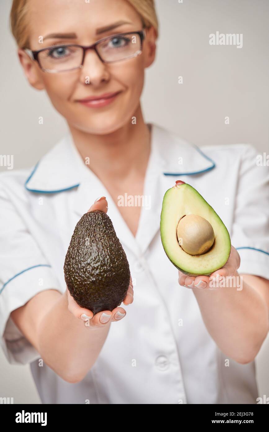 nutritionist doctor healthy lifestyle concept - holding organic avocado ...