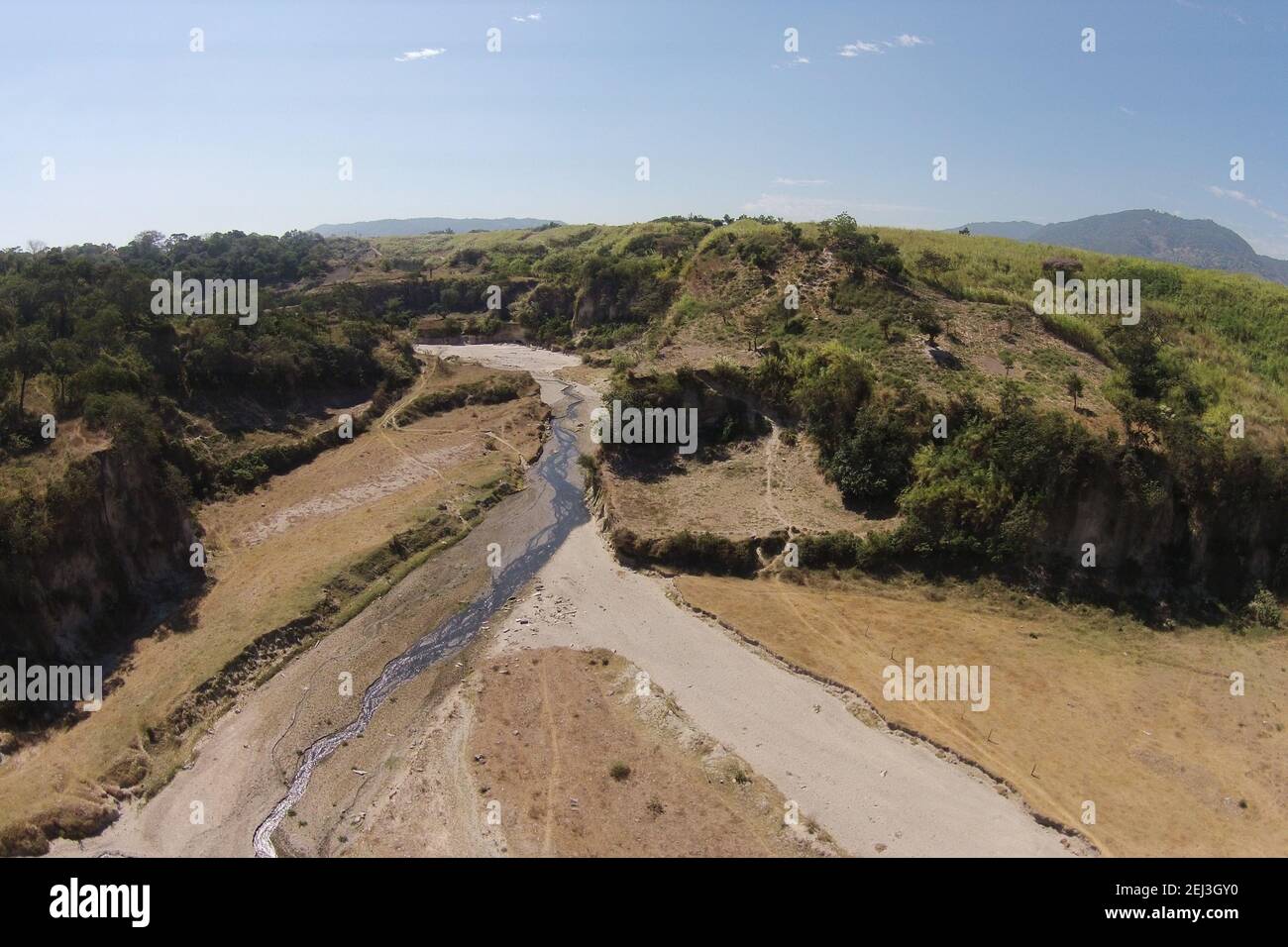 An aerial view of a tiny river between high hills Stock Photo - Alamy