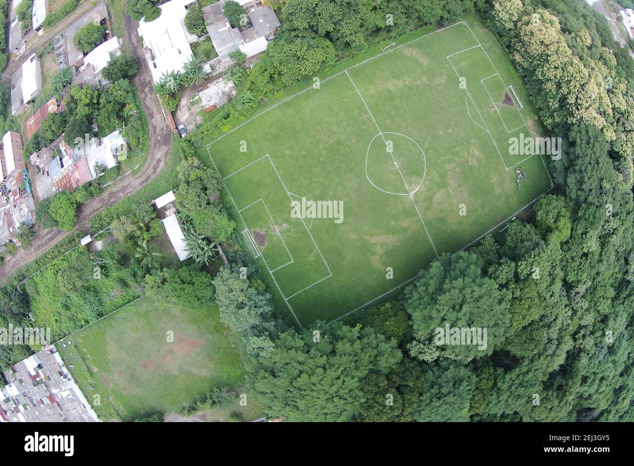 An aerial view of a football field surrounded by trees and buildings ...