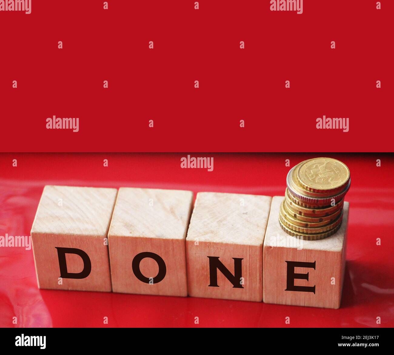 wooden cubes with message "done" on red background and coins. Business ...