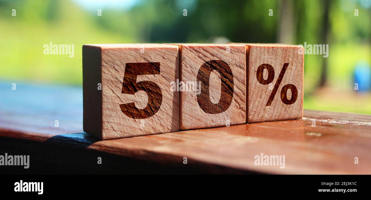50 percent written on wooden blocks on nature landscape background ...