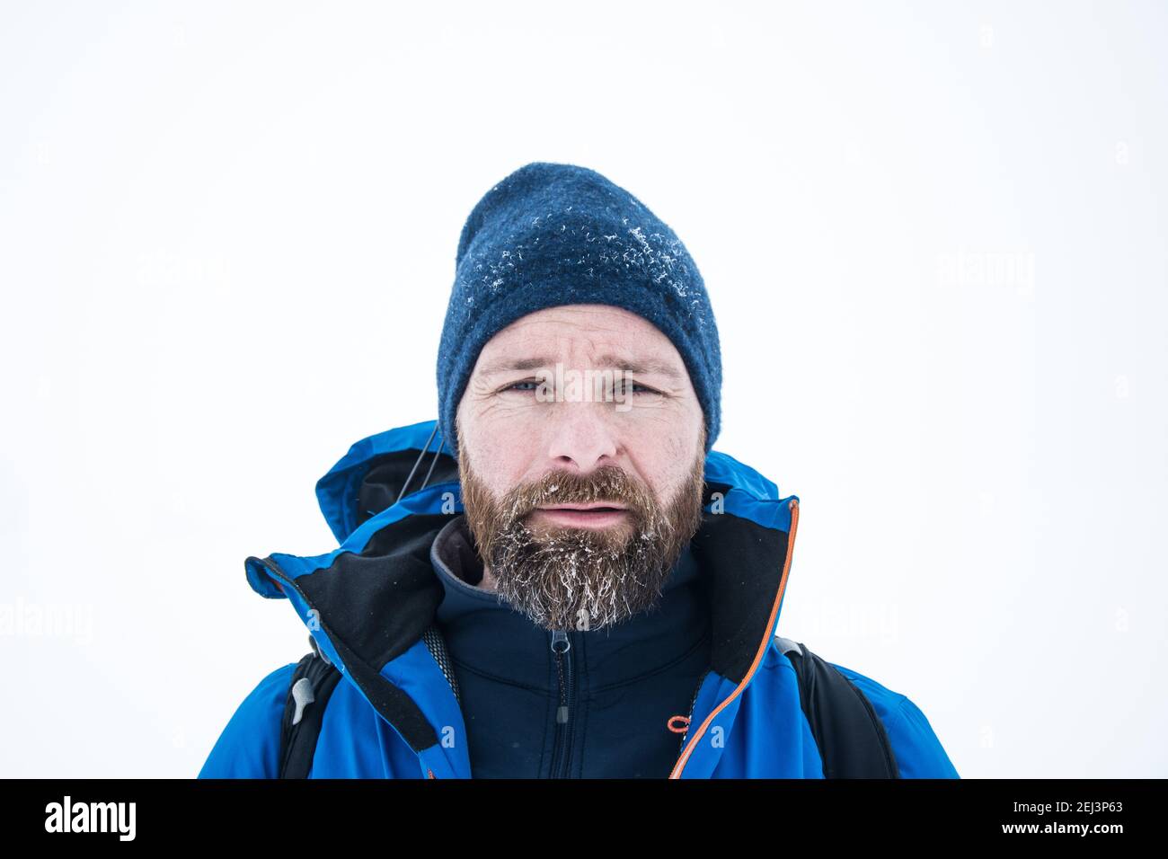 Portrait of the young man with frozen icy hairs on face and with beard ...