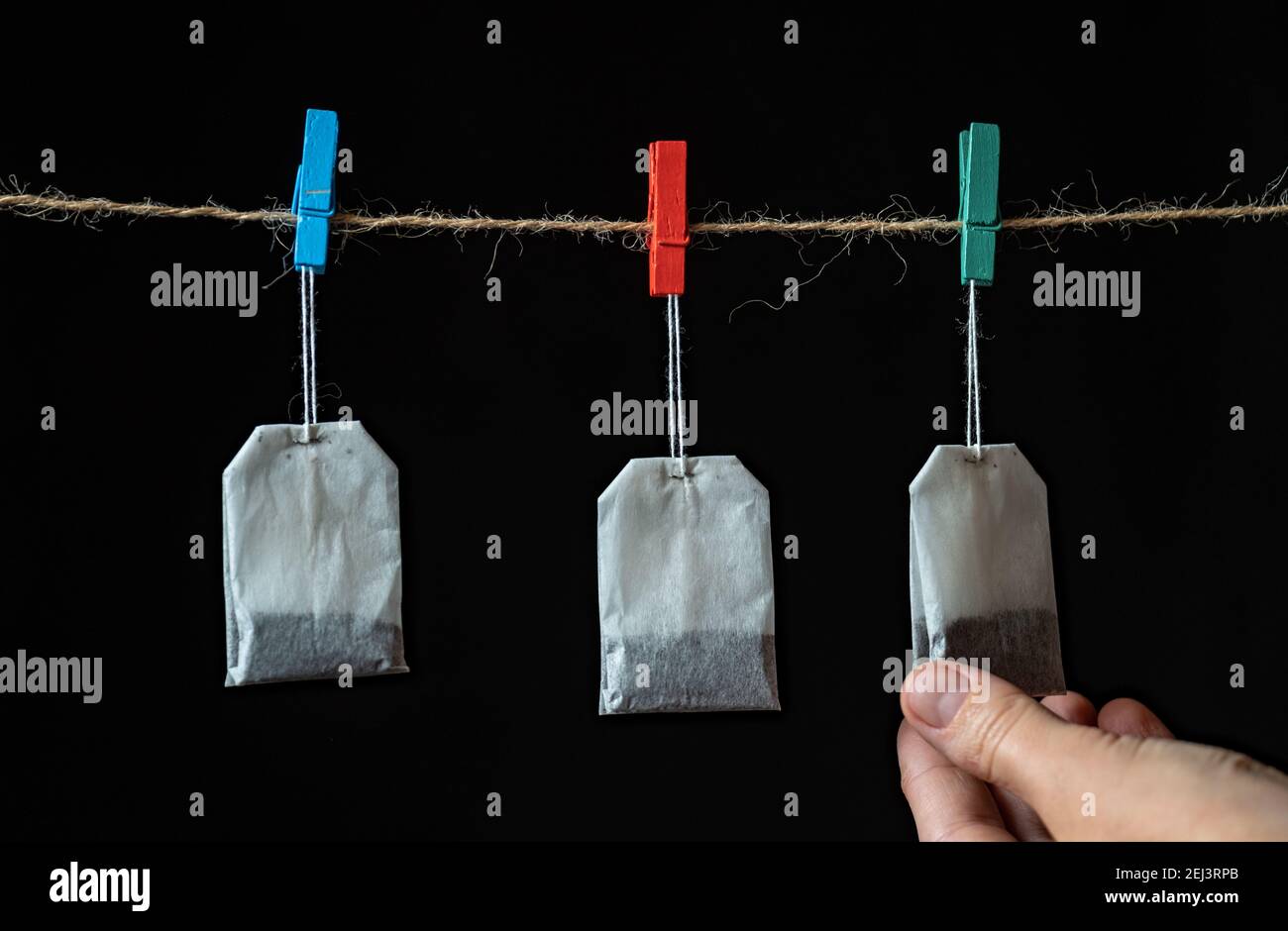 White Tea bags Isolated on background holding on rope, hand pick one ...