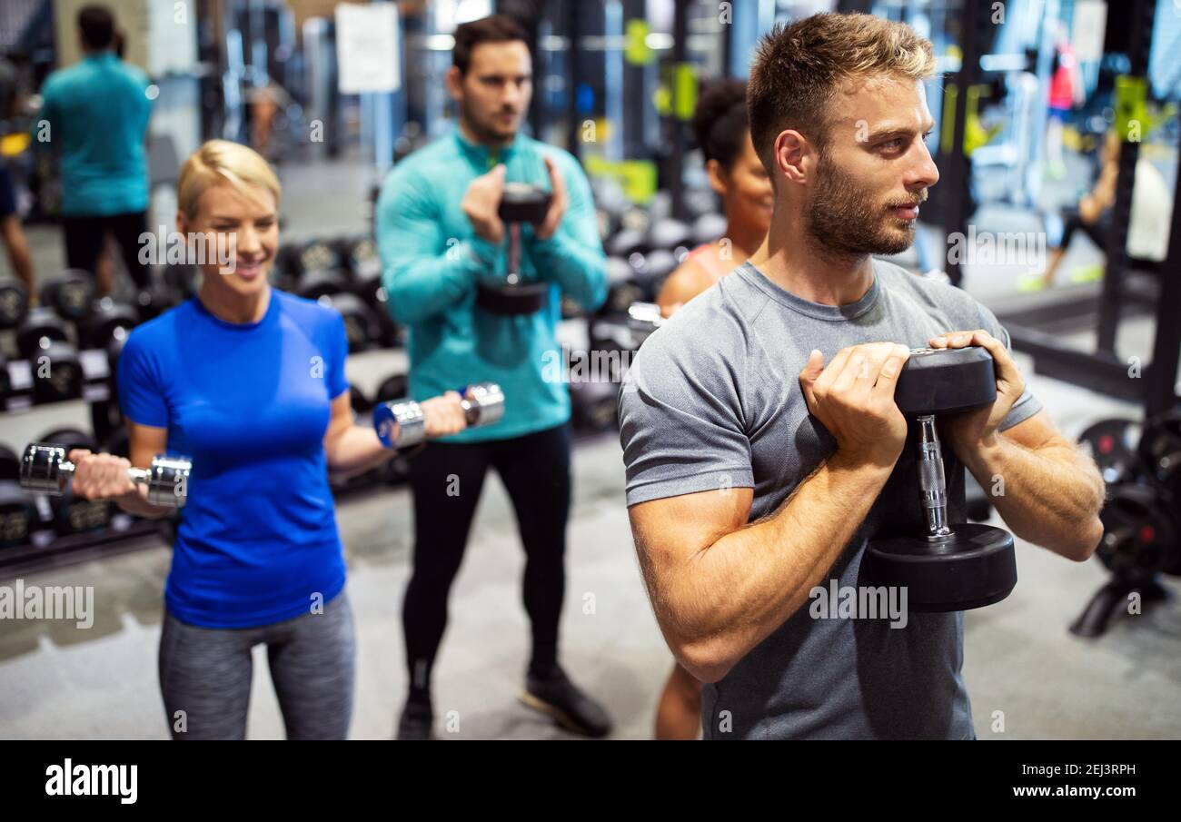 Group of young happy fit people doing exercises in gym Stock Photo - Alamy