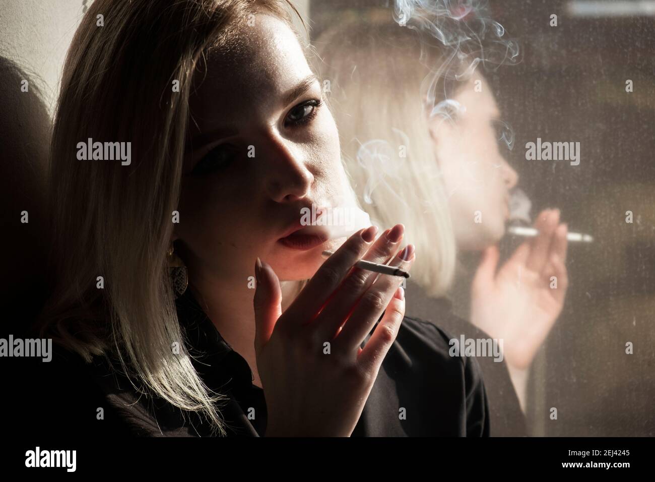 Close-Up Of Young Woman Smoking Cigarette By Window Stock Photo - Alamy