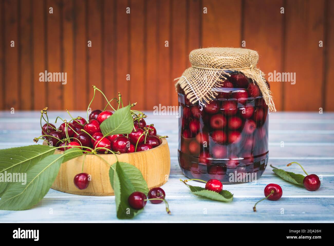 Cherry fruit compote. Preserved food in jar and fresh harvested red ...