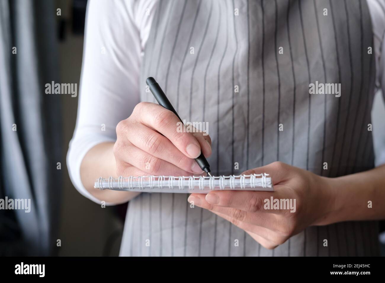 Waitress with a notebook and pen takes an order from the client and ...