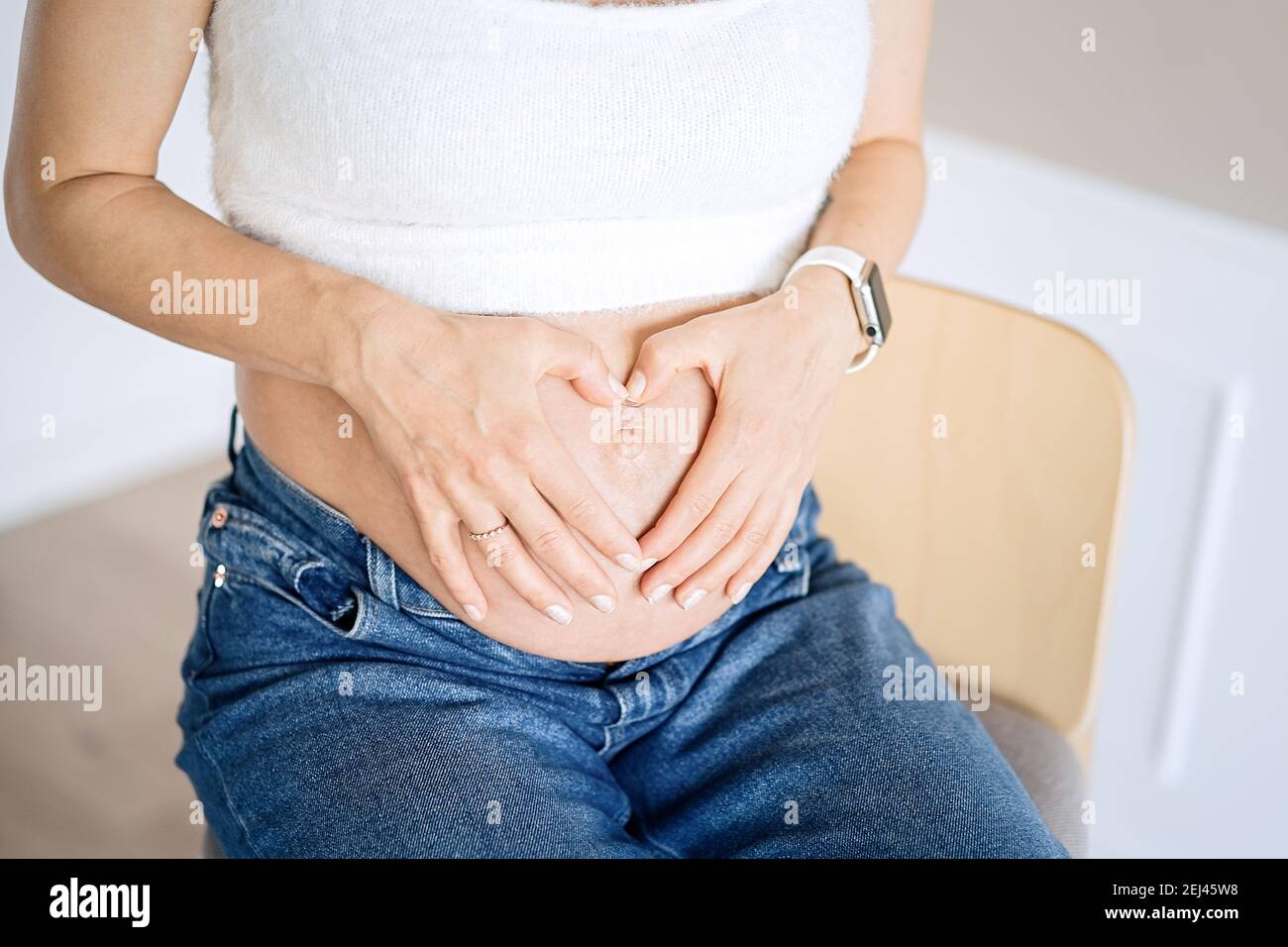 Pregnant woman hugging tummy, heart symbol on belly. Concept of ...