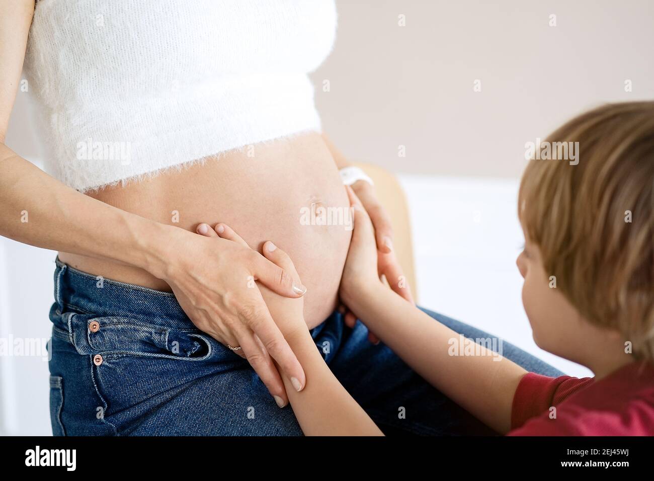 Pregnant mother and older brother hugging tummy at home Stock Photo - Alamy