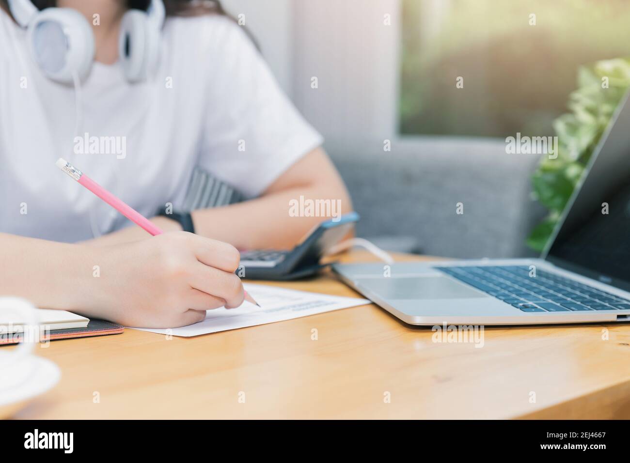 Young student watching lesson online and studying from home. She using ...