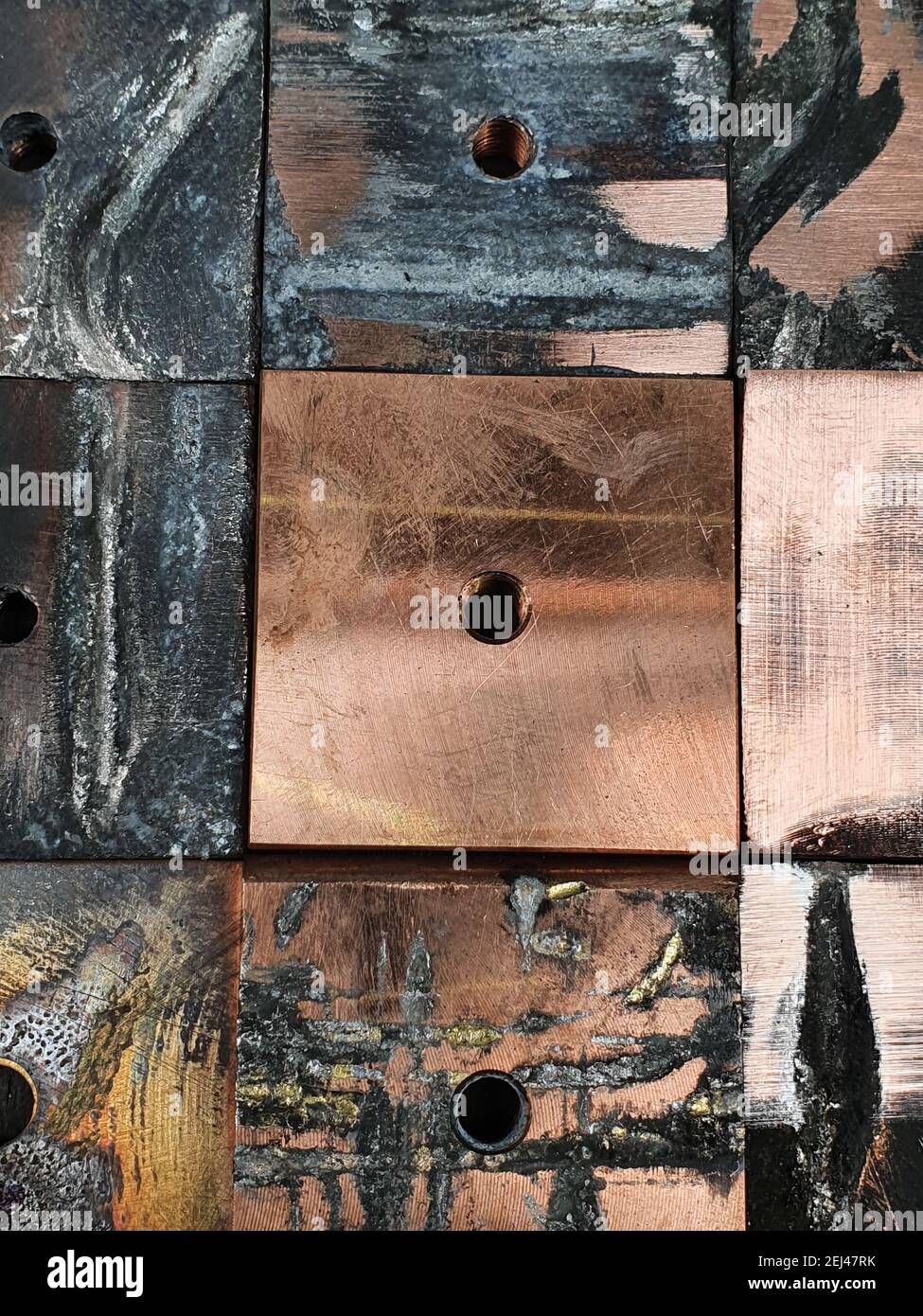 A vertical shot of piled stained brass with small holes in the middle ...