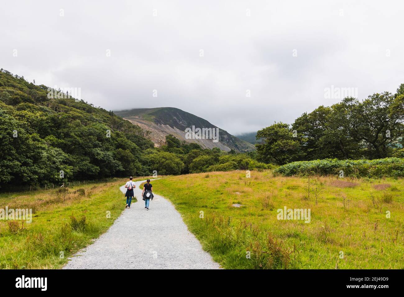 two people on their backs walking along a path in the direction of a ...