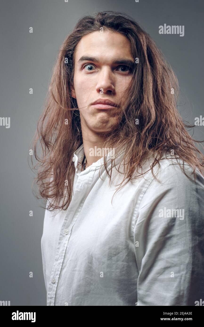 Funny guy with surprised expression. Comic cheerful young man with long ...