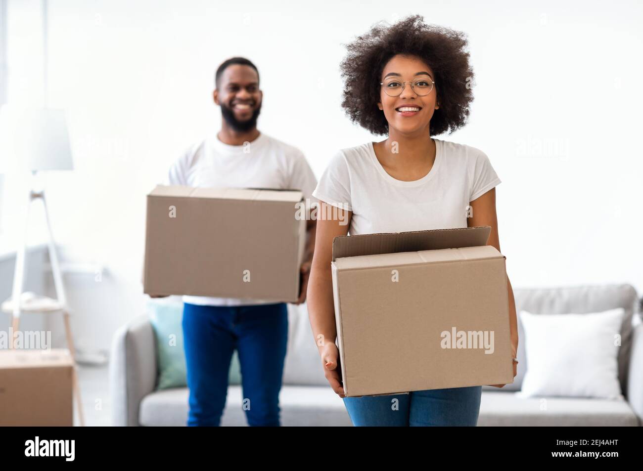 Black Couple Moving Carrying Packed Cardboard Boxes Into New Home Stock