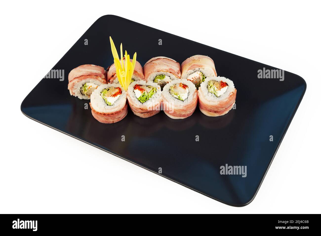 Sushi roll with bacon and fried sea bass on a black plate, ingredients ...