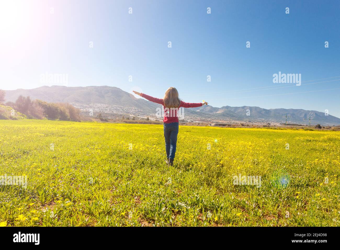 Image of a girl running through the field in a landscape full of yellow ...