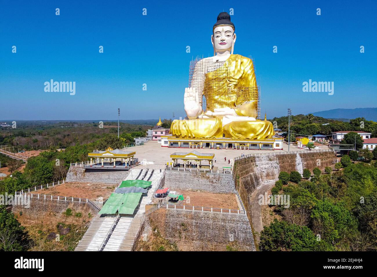 Aerial of a giant sitting buddha below the Kyaiktiyo Pagoda, golden ...
