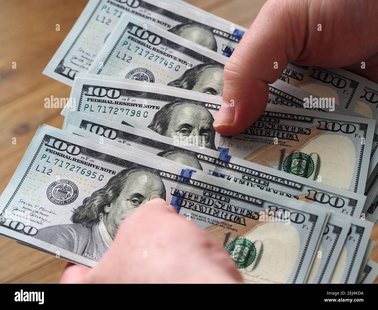 In this photo illustration, hands are seen counting US 100 dollar bills ...
