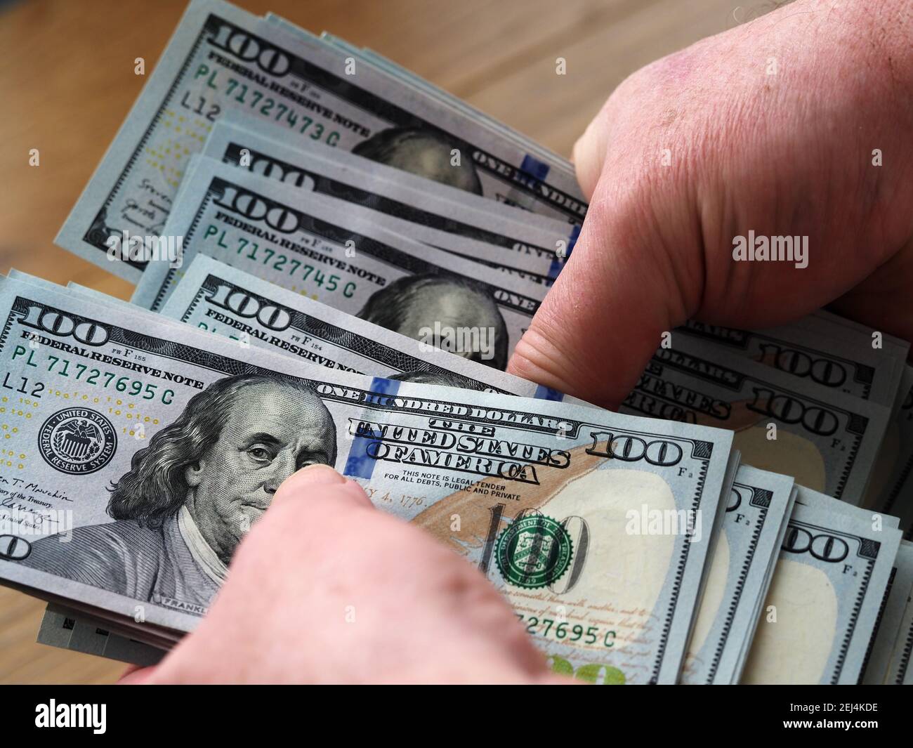 In this photo illustration, hands are seen counting US 100 dollar bills ...